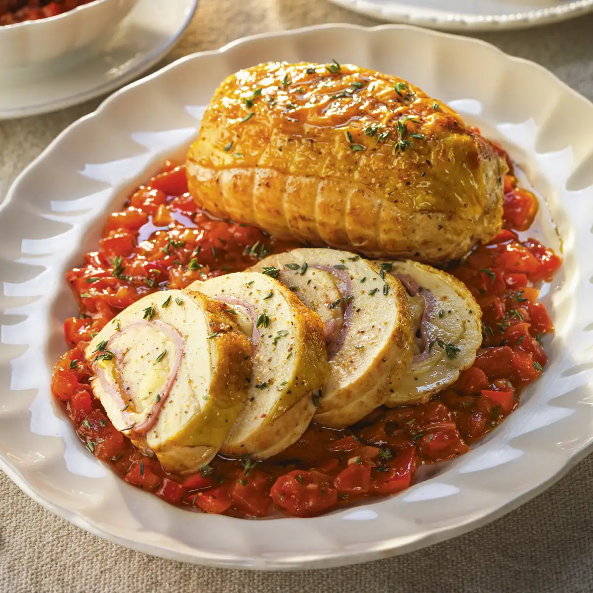 Roti de pollo relleno de jamón y queso con pisto rojo